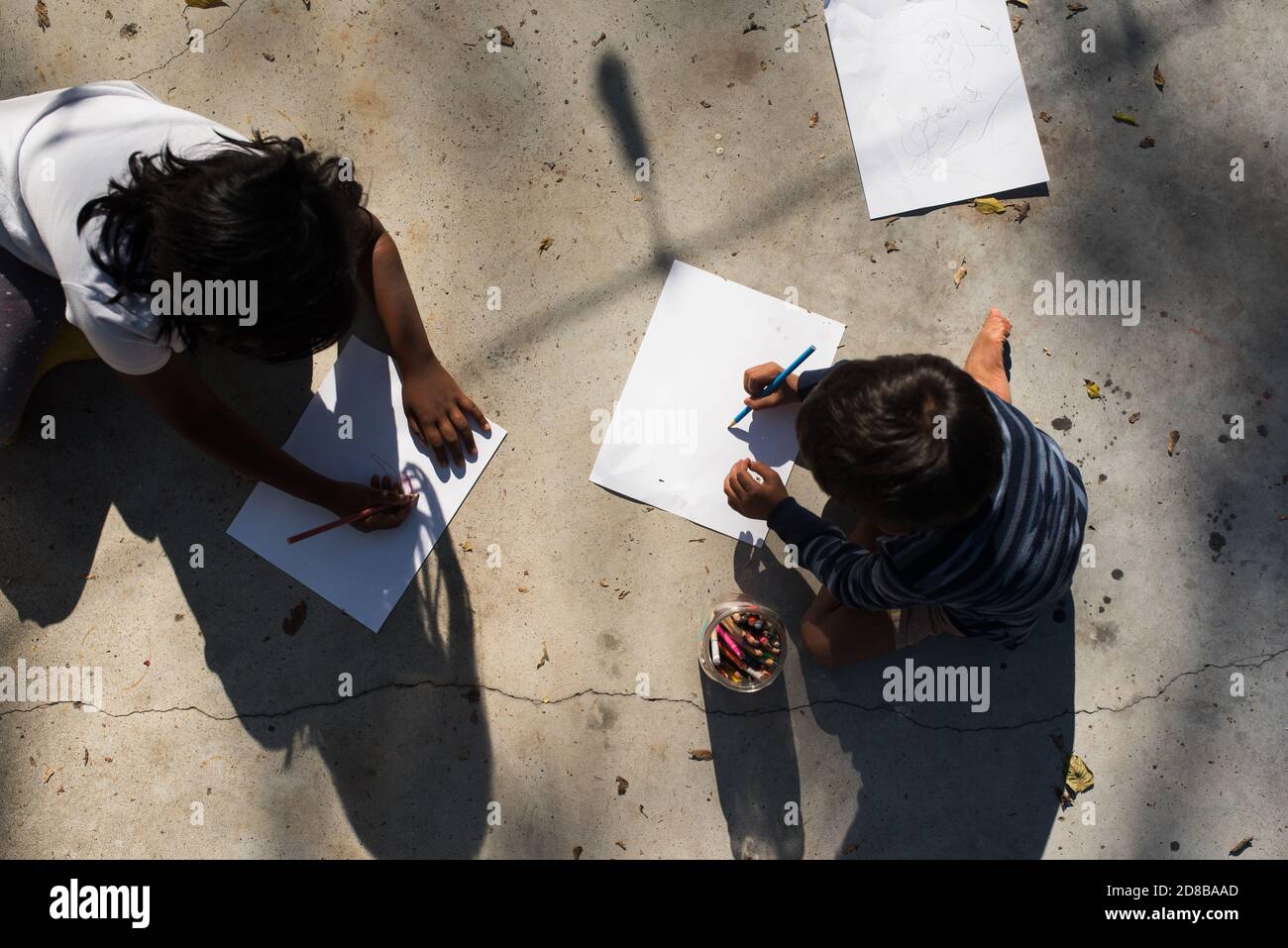 Children drawing on paper outside from above Stock Photo - Alamy