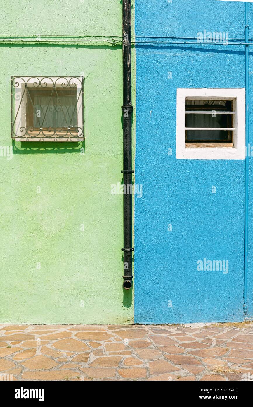 Two tone wall in Burano, Venice: green and blue with two small windows ...