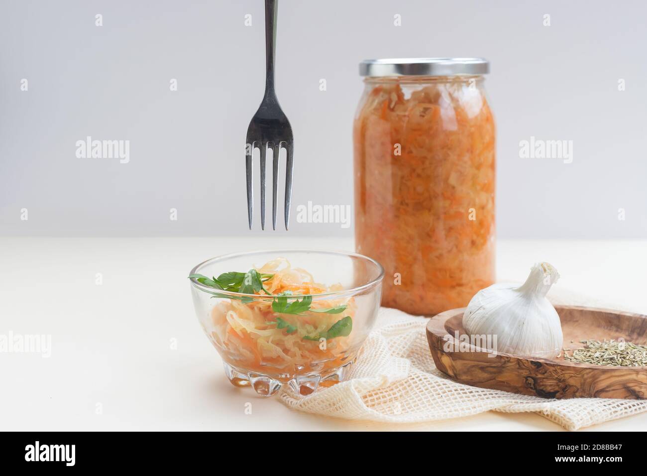 eating fermented cabbage with a fork, a jar with fermented cabbage ...