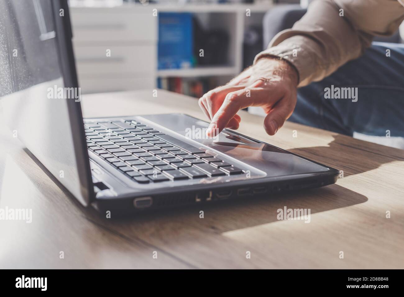 Closeup of men's hand on laptop computer. User at home surfing in the ...