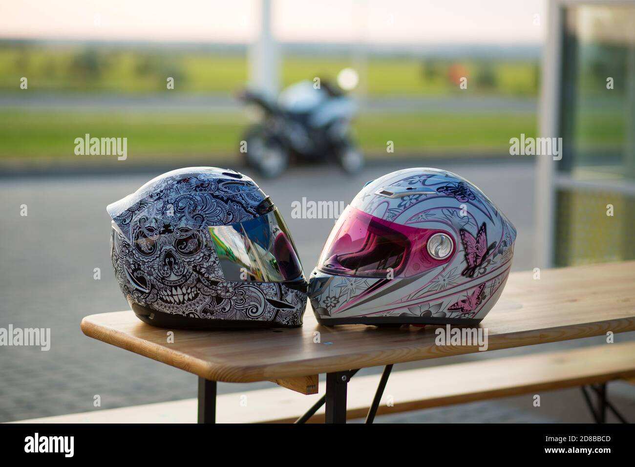 Biker romance. Male and female motorcycle helmets on the background of a motorcycle Stock Photo Alamy