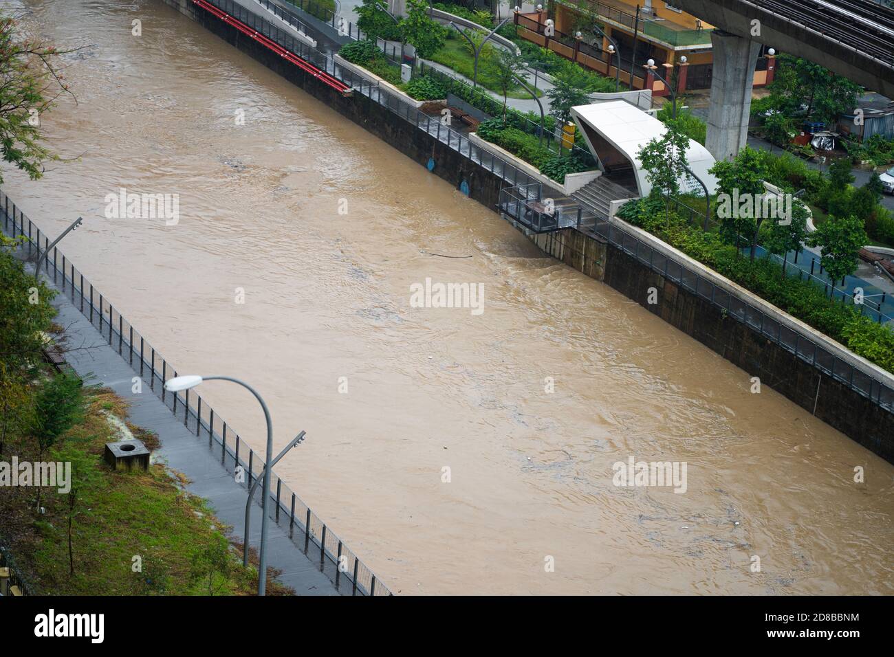 River canal in a big city. Sewage after rain carries garbage along the ...
