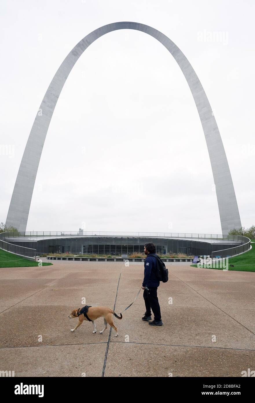 St. Louis, United States. 28th Oct, 2020. A man walks his dog past the ...