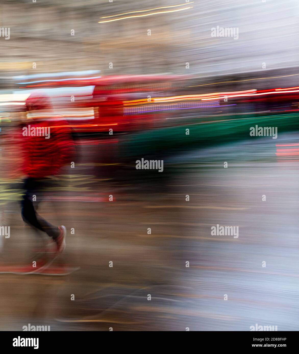 Red London bus moving fast along Piccadilly; rainy afternoon, wet ...