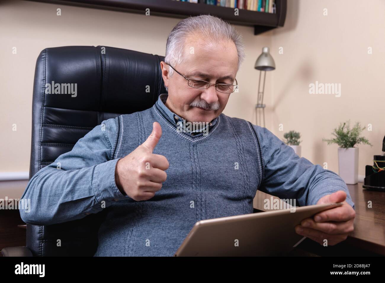 Senior man reading news on digital tablet. Senior man using tablet ...