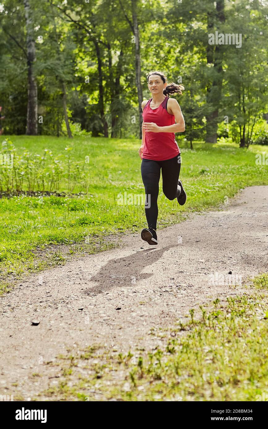 Athletic white woman runs in public park at morning Stock Photo - Alamy
