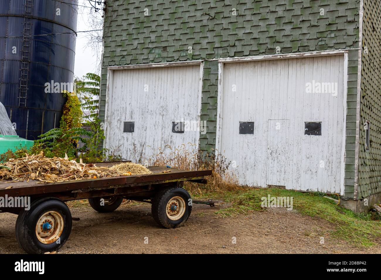 A farm wagon is parked in front of the canopy garage doors of a grain ...