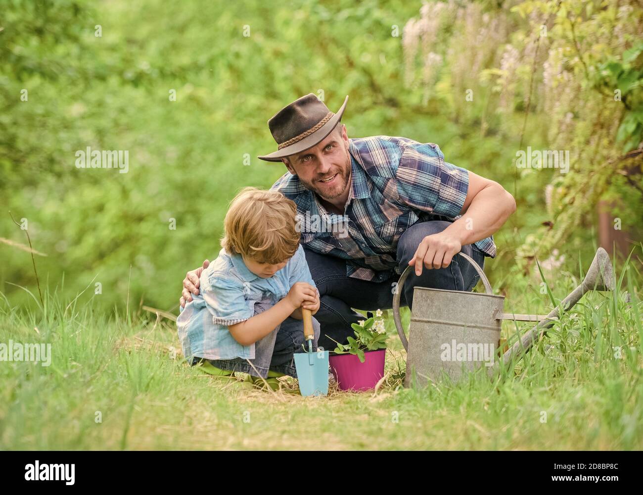 Boy and father in nature with watering can. Gardening tools. Planting ...