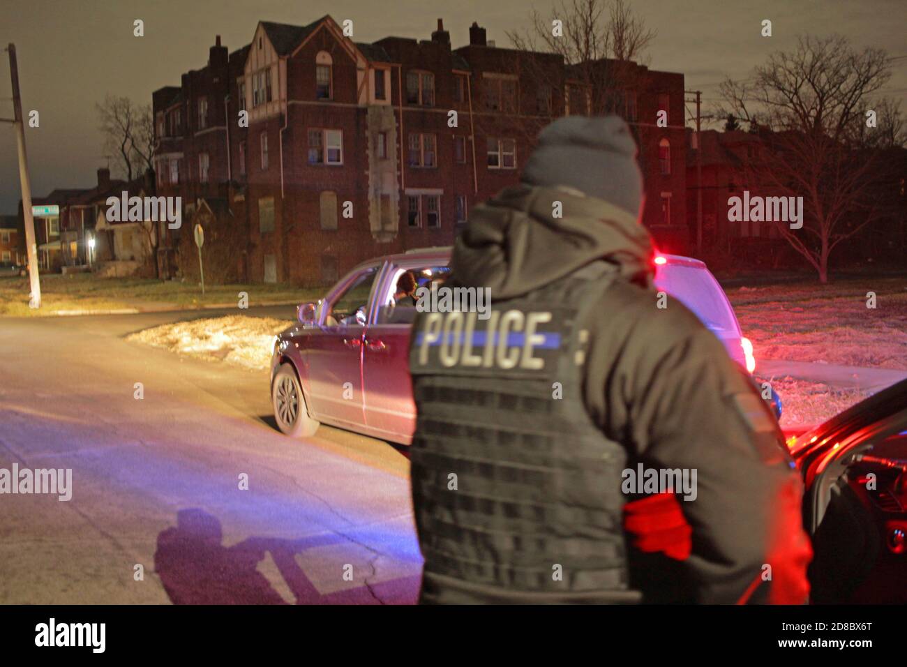 Detroit police officer checks a vehicle in the street at night, Detroit ...
