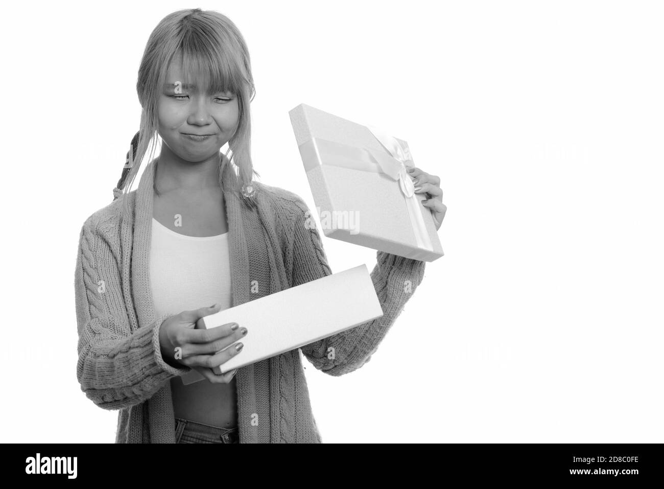 Young cute Asian woman opening gift box looking disappointed Stock ...
