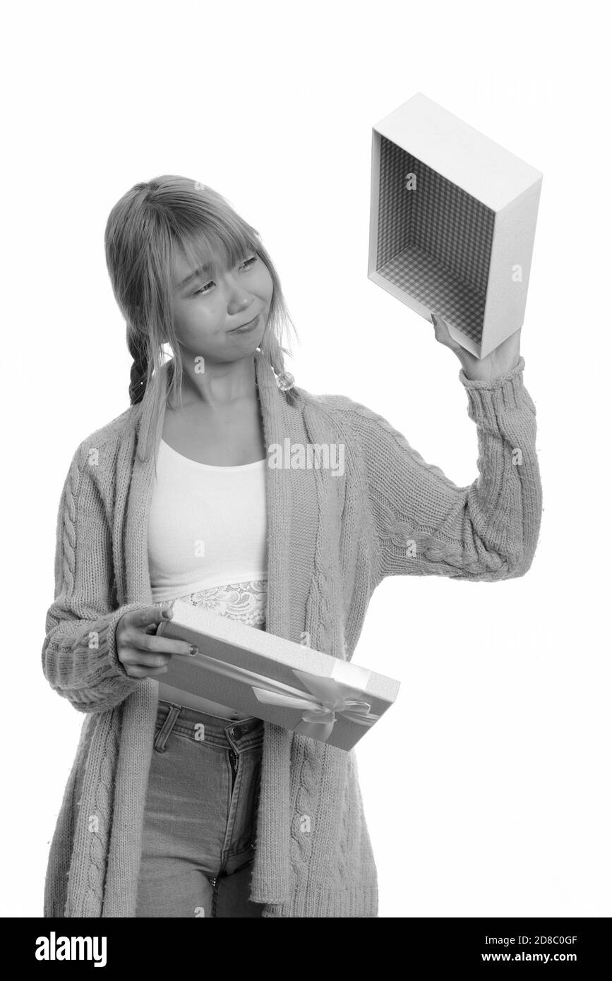 Young cute Asian woman holding empty gift box upside down looking ...