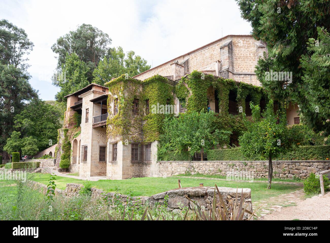 Monastery of Yuste surrounded by greenery under a cloudy sky and ...