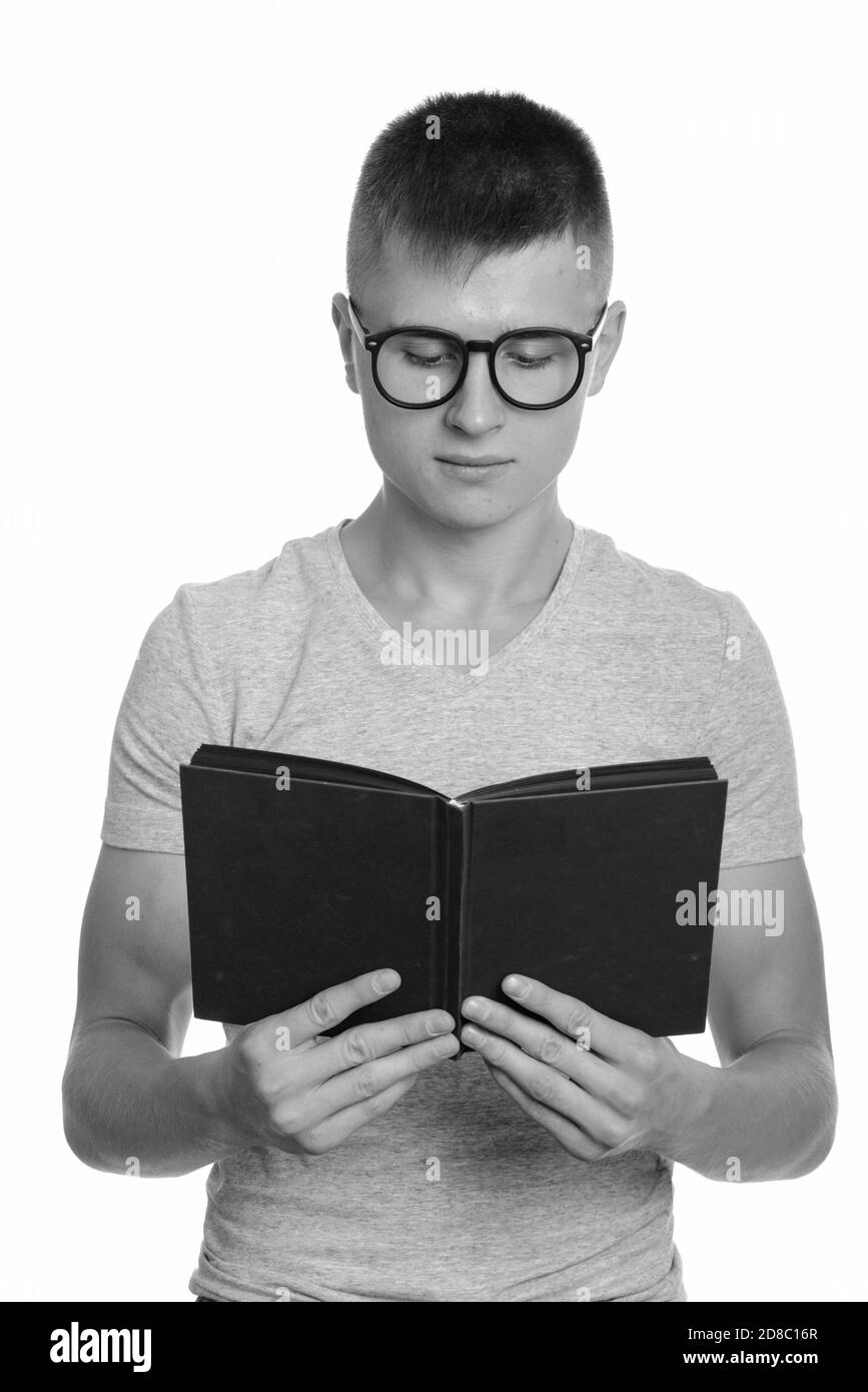 Portrait of young handsome nerd man reading book with eyeglasses Stock ...
