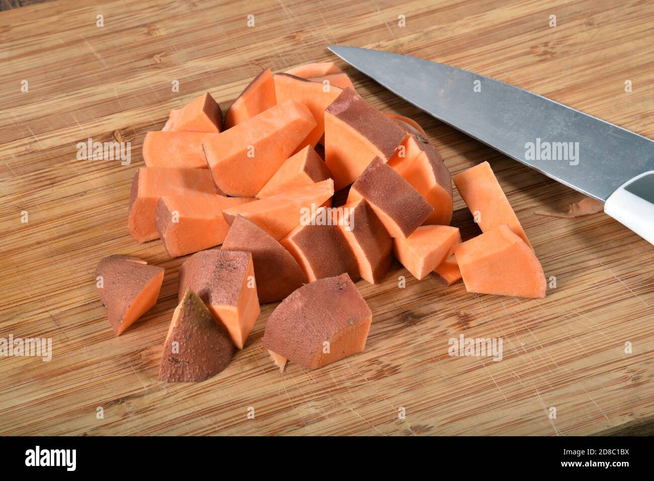 A mound of diced sweet potatoes on a cutting board Stock Photo - Alamy