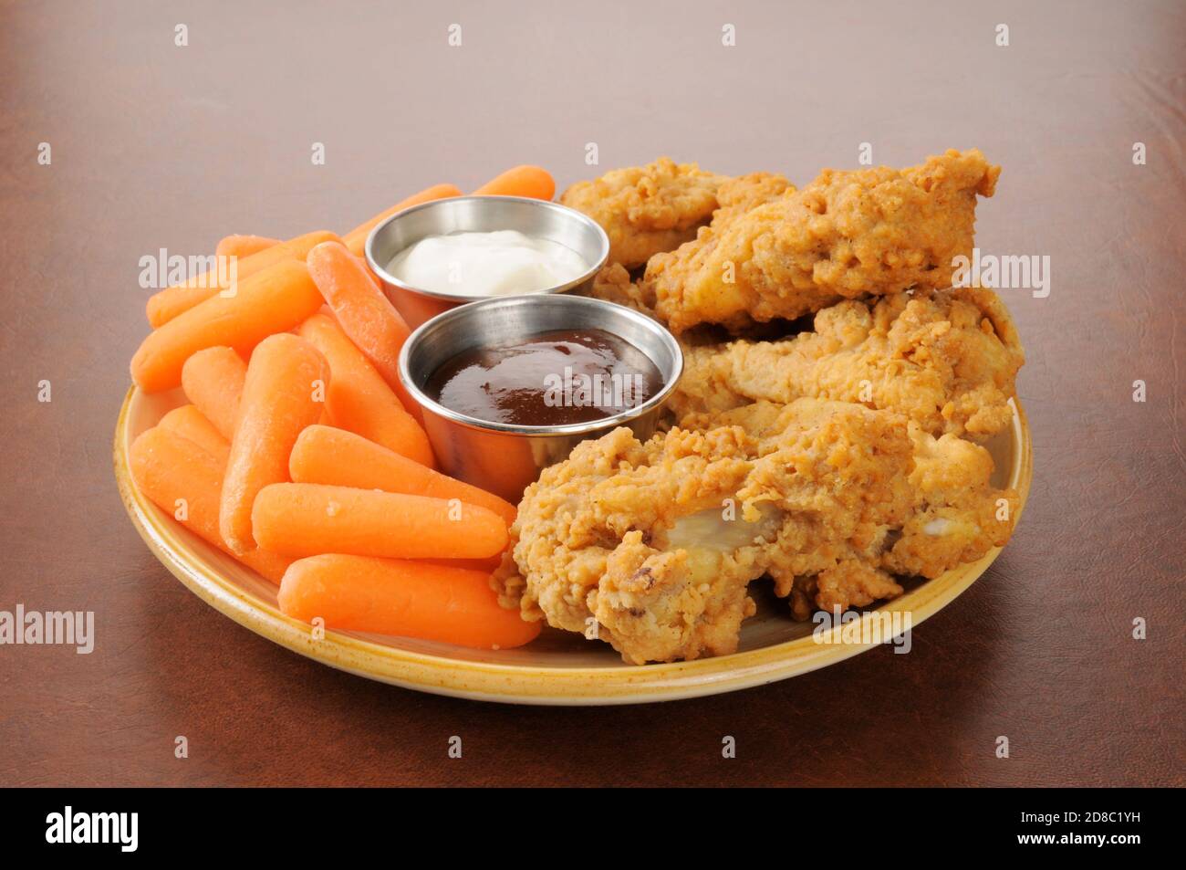 chicken wings and carrot sticks with ranch dressing and barbecue sauce ...
