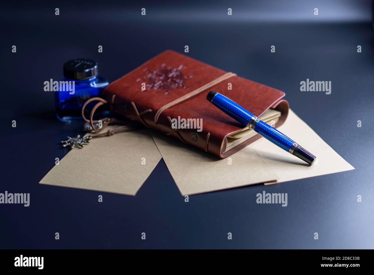 blue pen on brown book and ink Stock Photo - Alamy