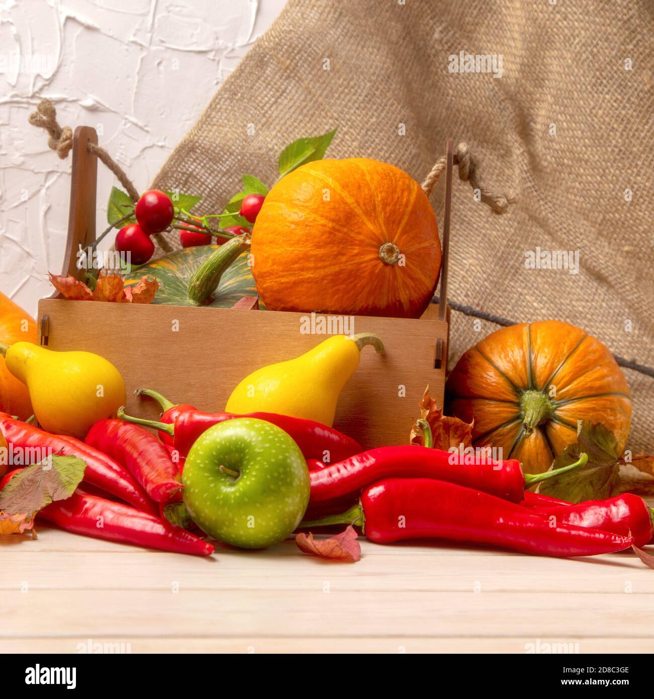 Rustic fall background with wooden box, pumpkin, red hot chili peppers ...