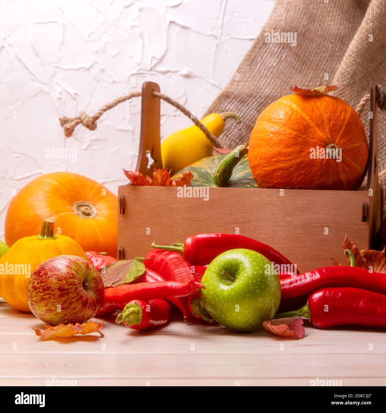 Rustic fall background with wooden box, pumpkin, red hot chili peppers ...