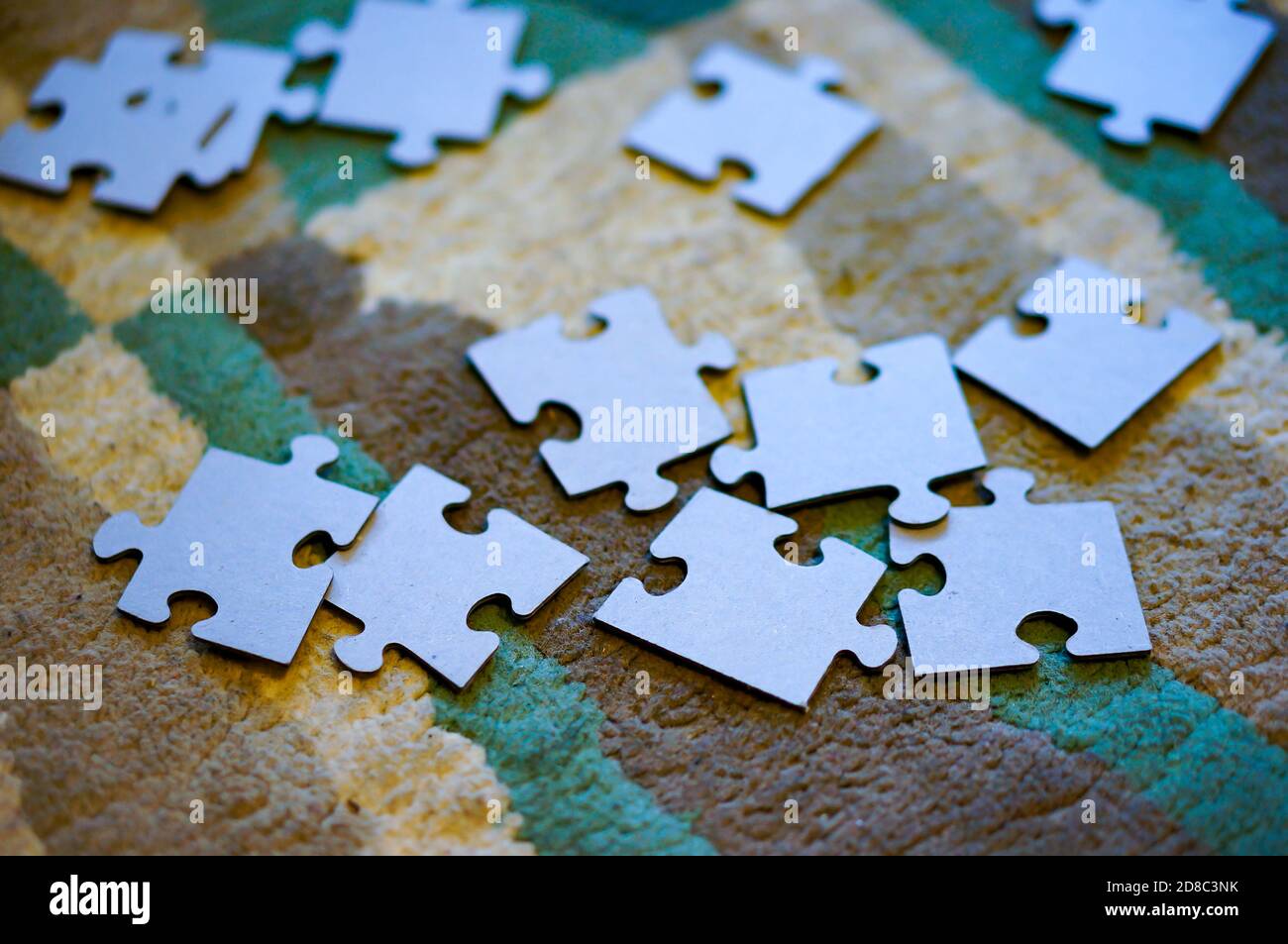 Closeup of multiple upside-down puzzle pieces placed on a colorful ...
