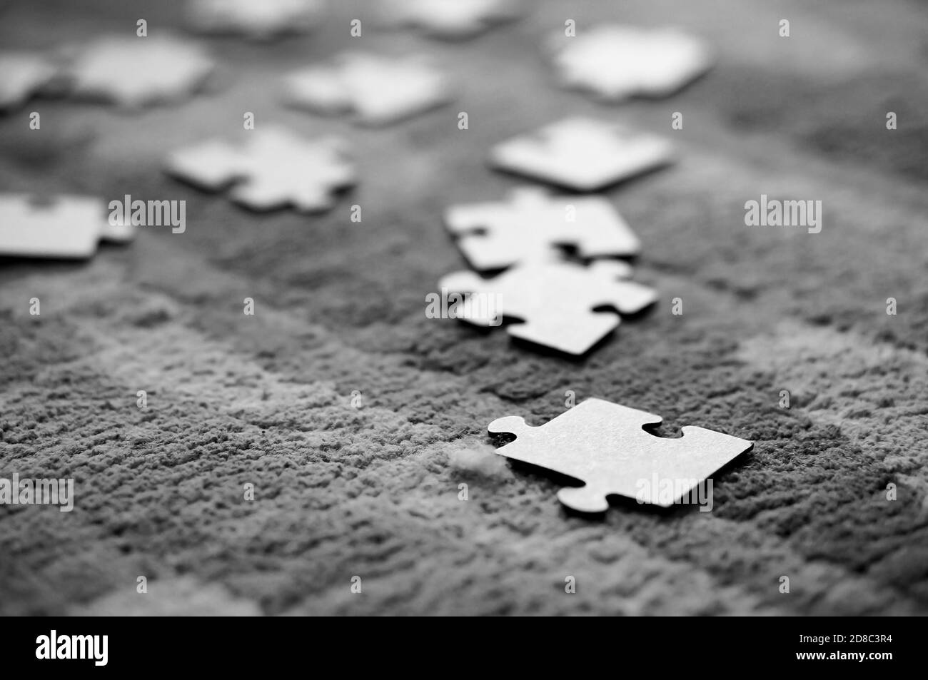 Closeup of various upside-down puzzle pieces placed on a fluffy carpet ...
