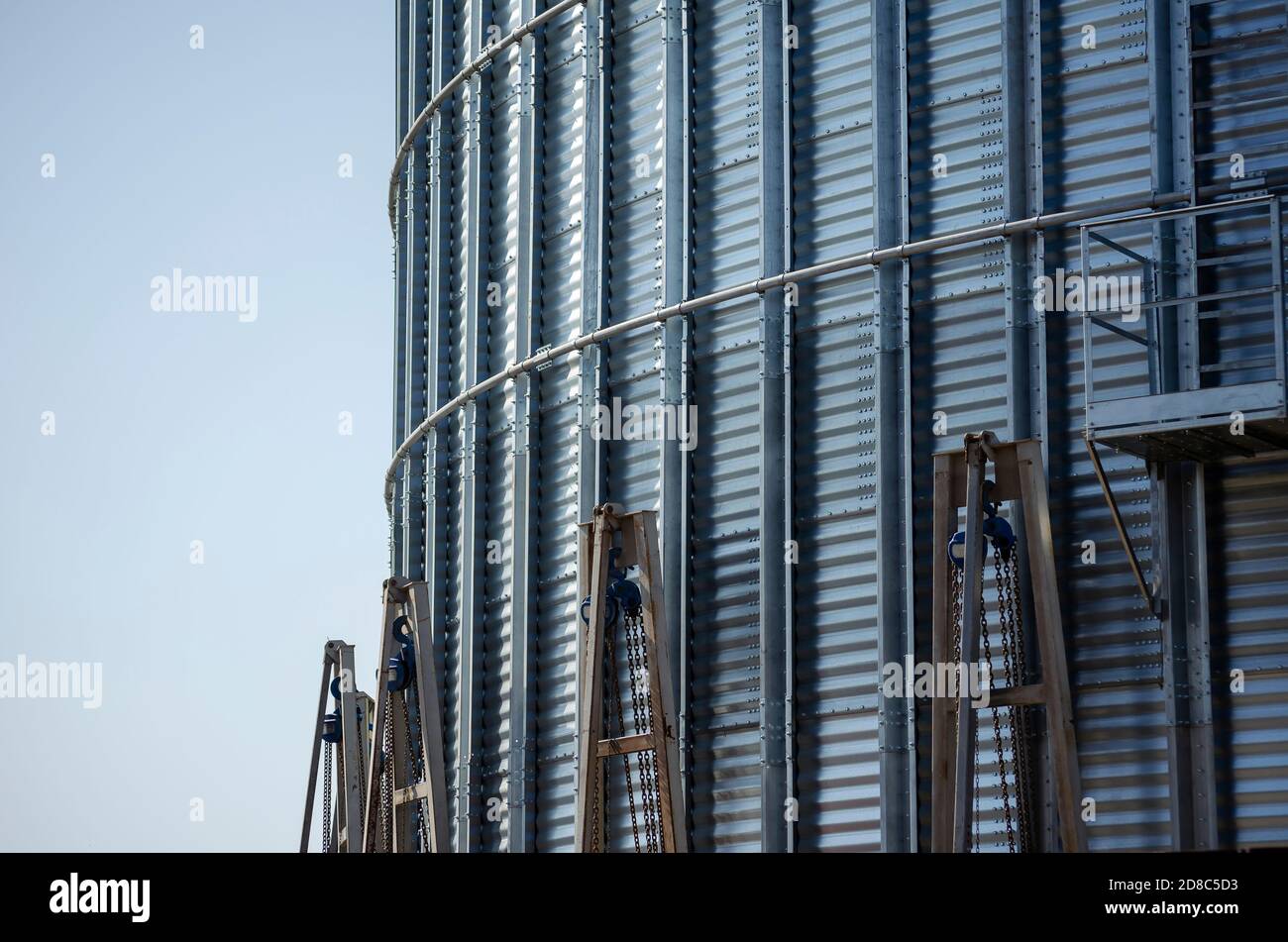 Construction of a metal grain storage. Mechanical jacks around the ...