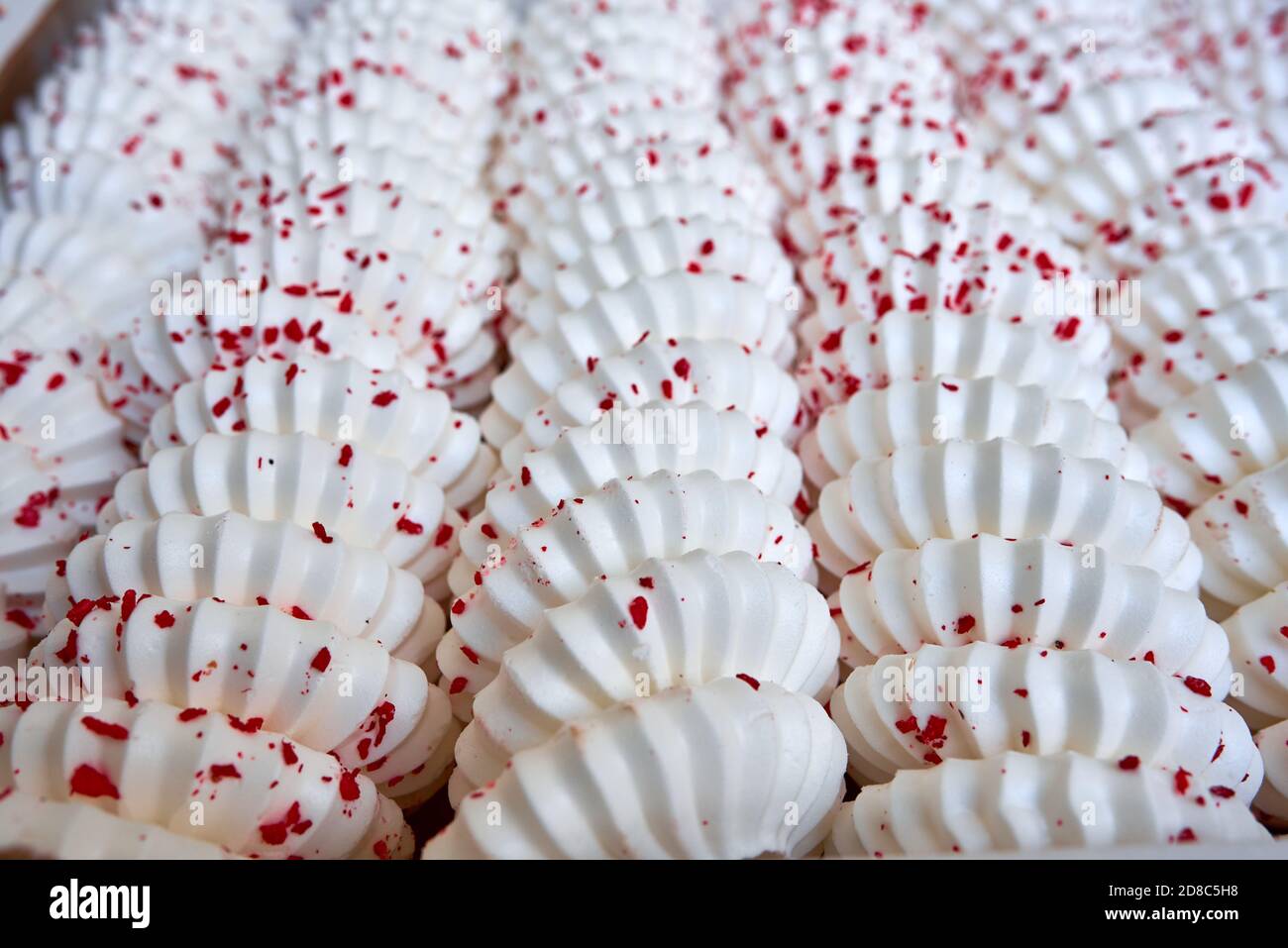 Background of white meringue cakes with red pastry crumb sprinkles ...