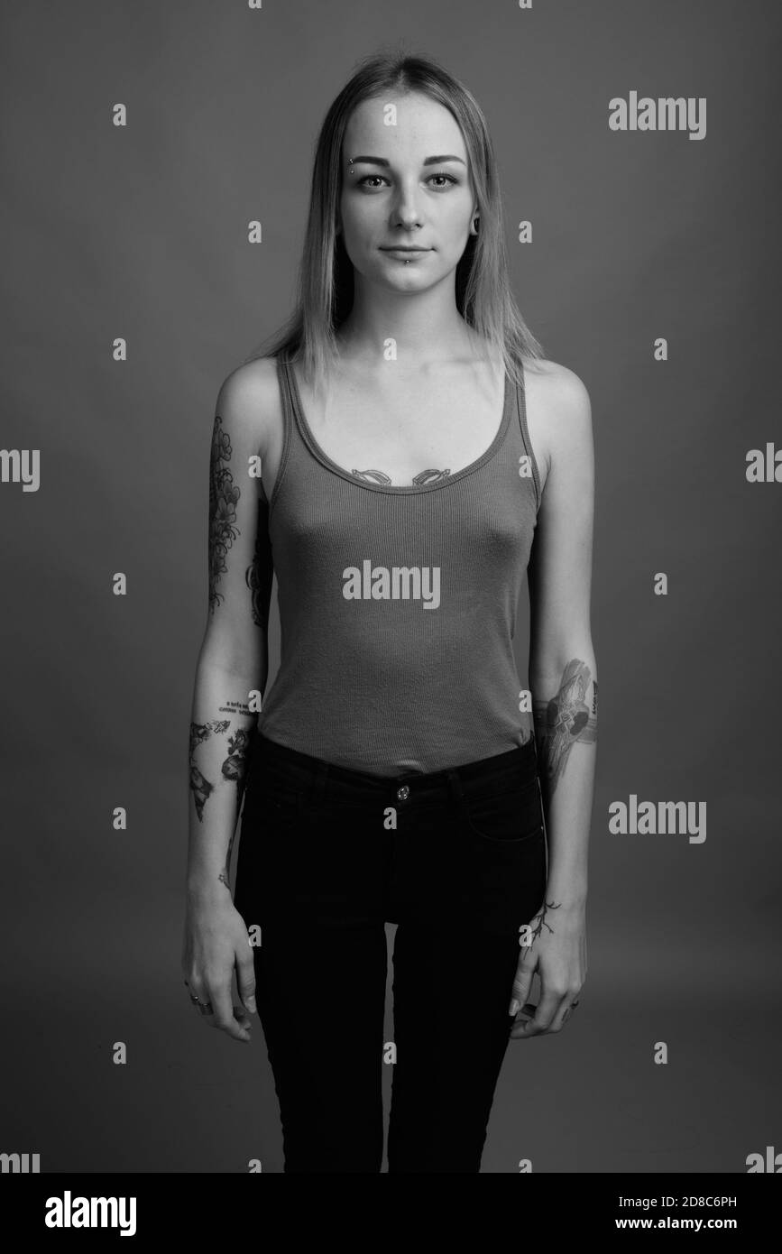 Young beautiful rebellious woman with dyed hair against gray background ...