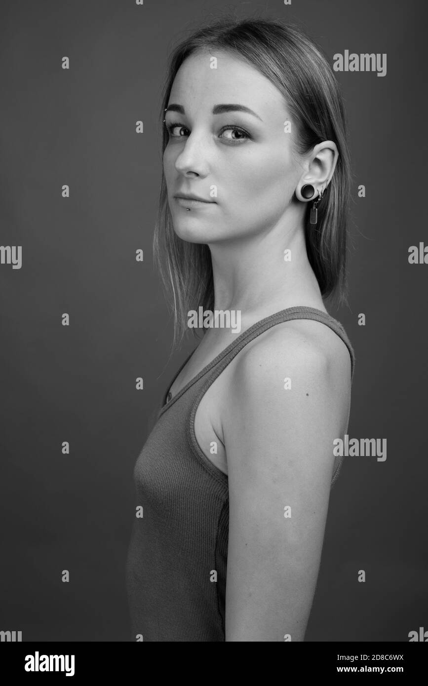 Young beautiful rebellious woman with dyed hair against gray background ...