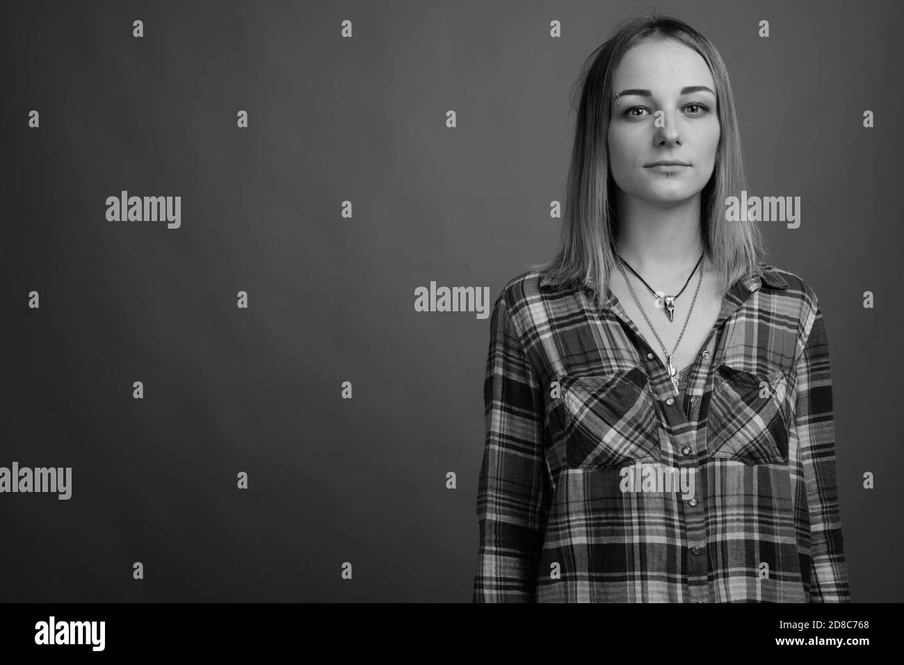 Young beautiful rebellious woman with dyed hair against gray background ...