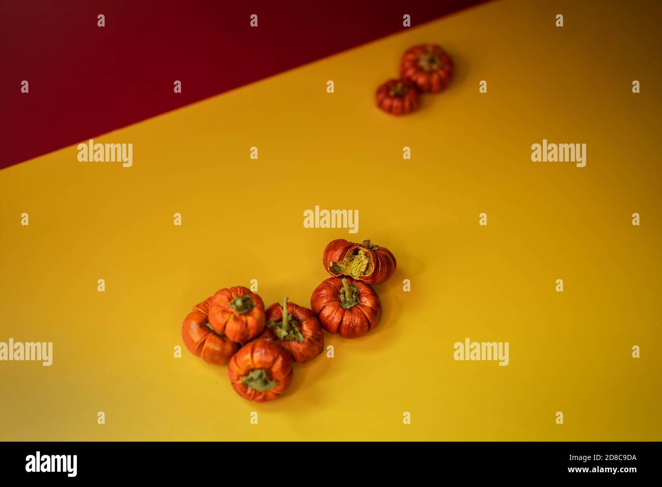 Group of little pumpkins over yellow surface and red background Stock ...