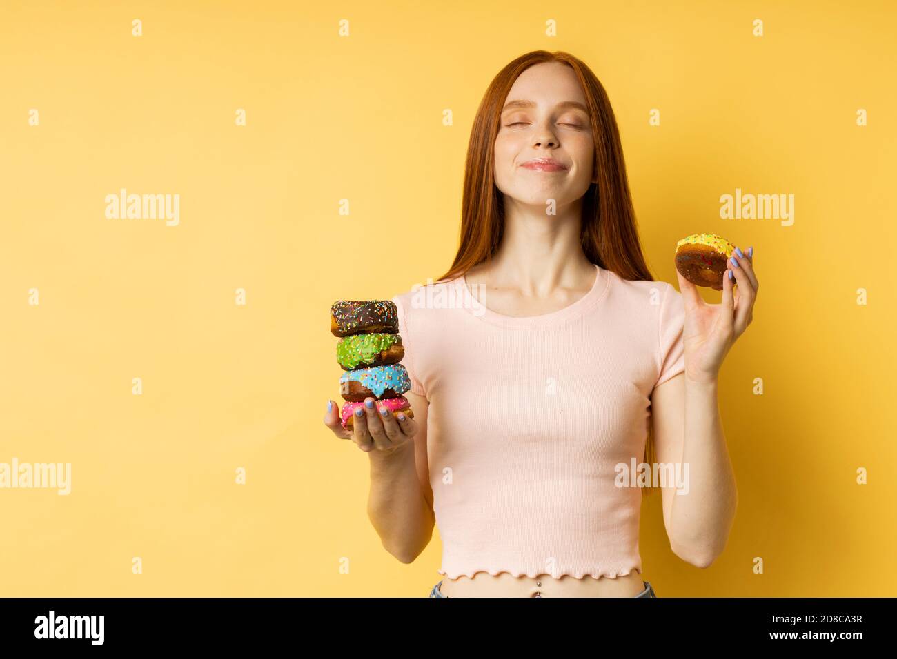 Lovely caucasian ginger lady sweet tooth holding delicious colorful ...
