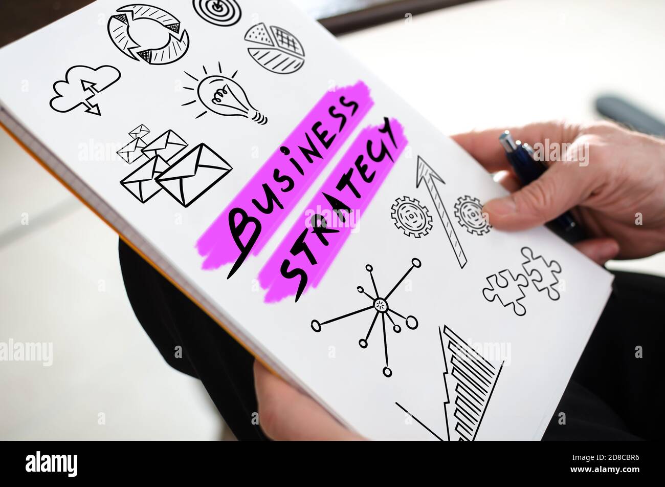 Business strategy concept on a paper held by a hand Stock Photo - Alamy
