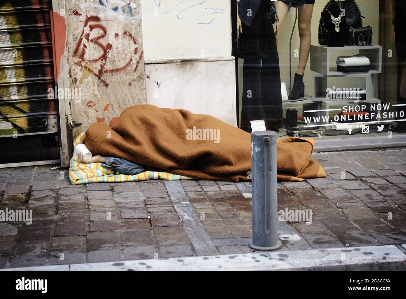 Homeless person sleeping on a street pavement, Athens, Greece, November ...