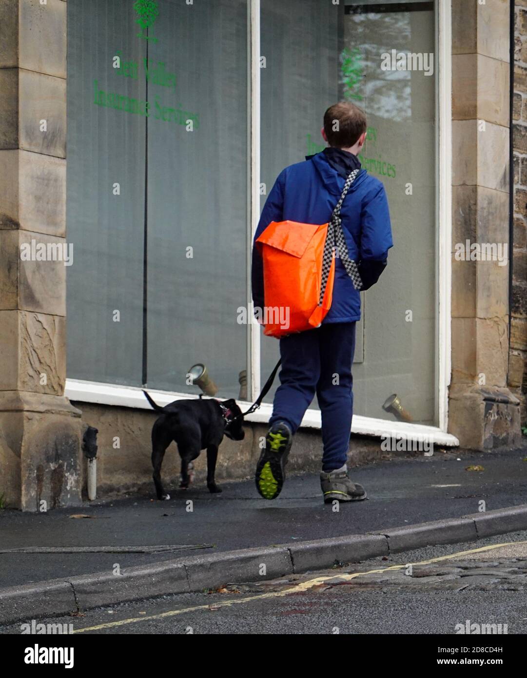 A paperboy combines delivering papers and walking his dog Stock Photo ...