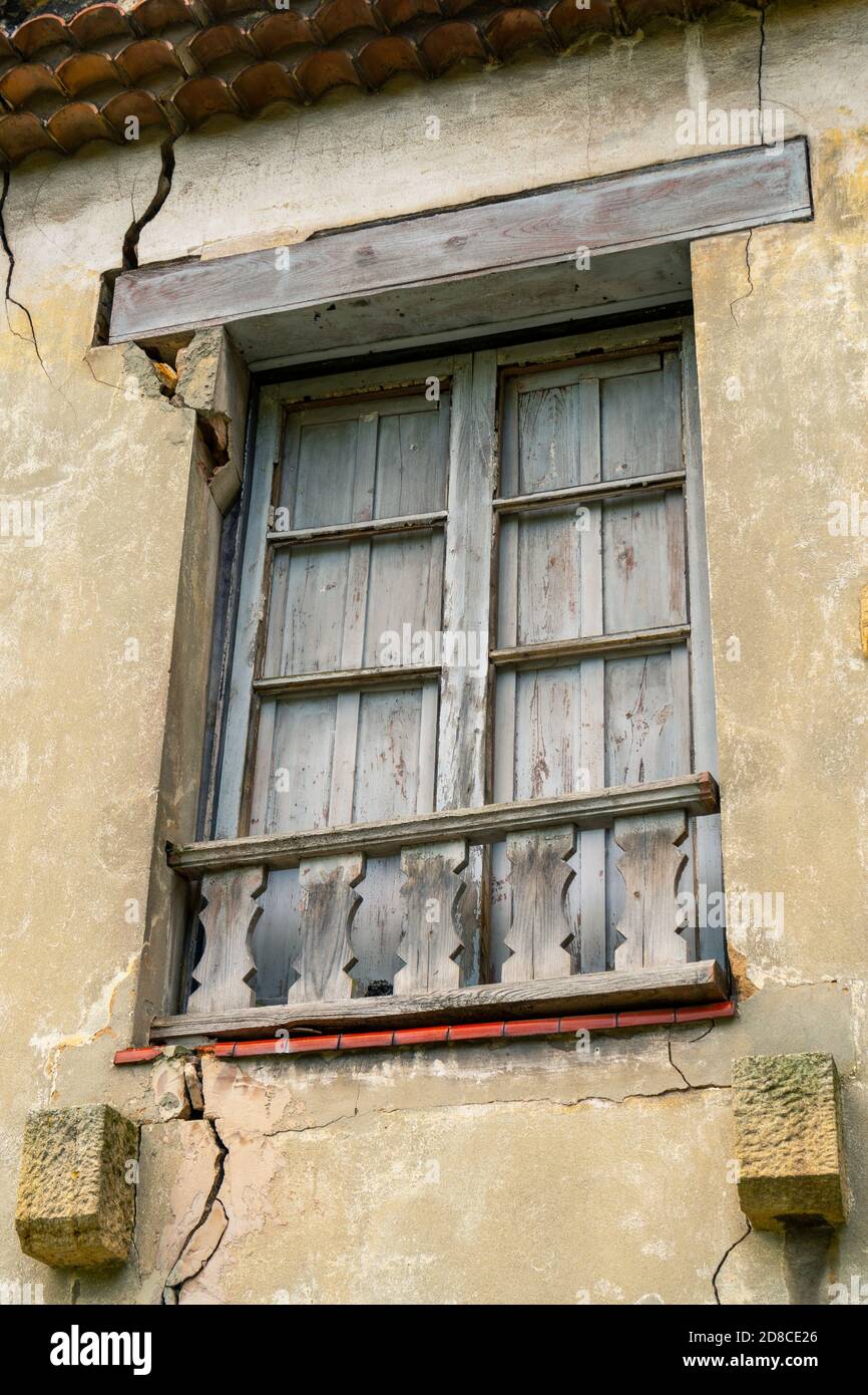 Broken Window of a ruined abandoned house with cracked walls and closed ...
