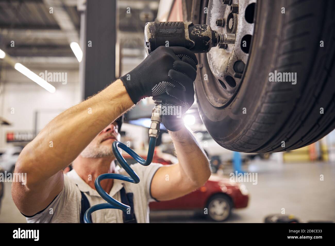 Professional mechanic repairing car wheel disk in garage Stock Photo ...