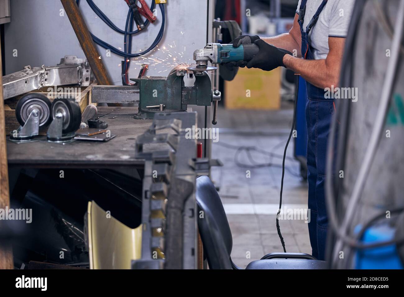 Mechanic grinding car metal parts in garage Stock Photo - Alamy