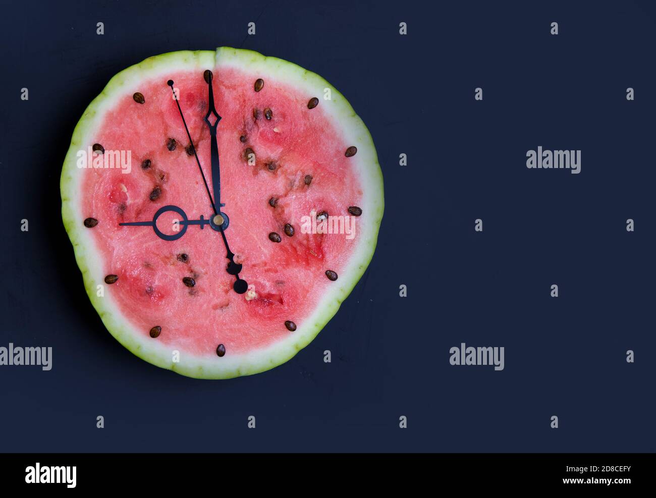 Watermelon slice with arrows showing nine o'clock on the clock, dark ...
