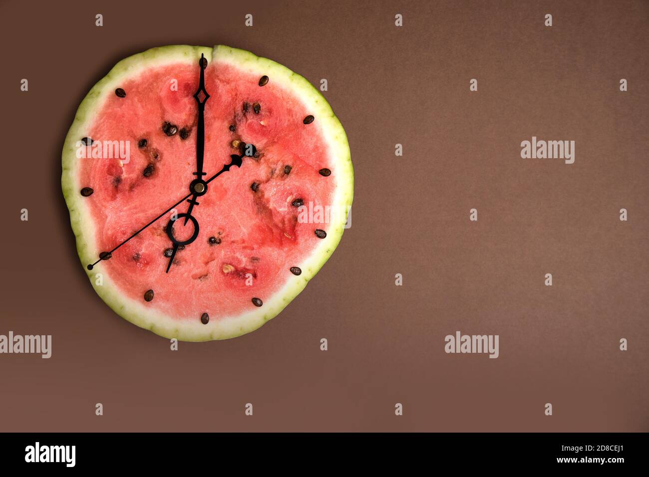 Cut of a ripe watermelon in the form of a clock, the hands show seven ...