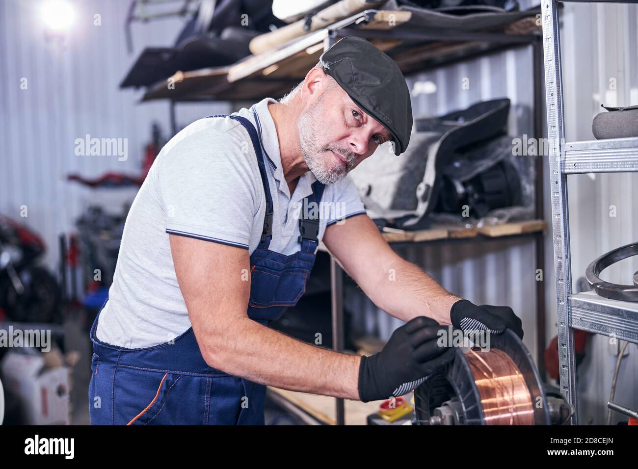 Handsome mechanic using copper wire at vehicle repair shop Stock Photo ...