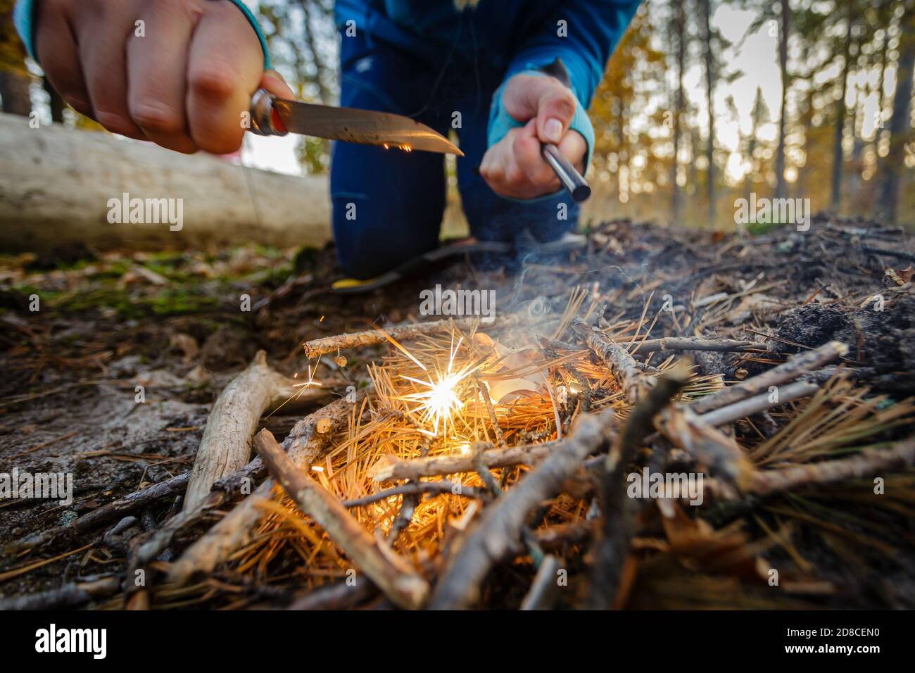 Man outdoors makeing fire by flint. Front view. Flying sparks Stock ...
