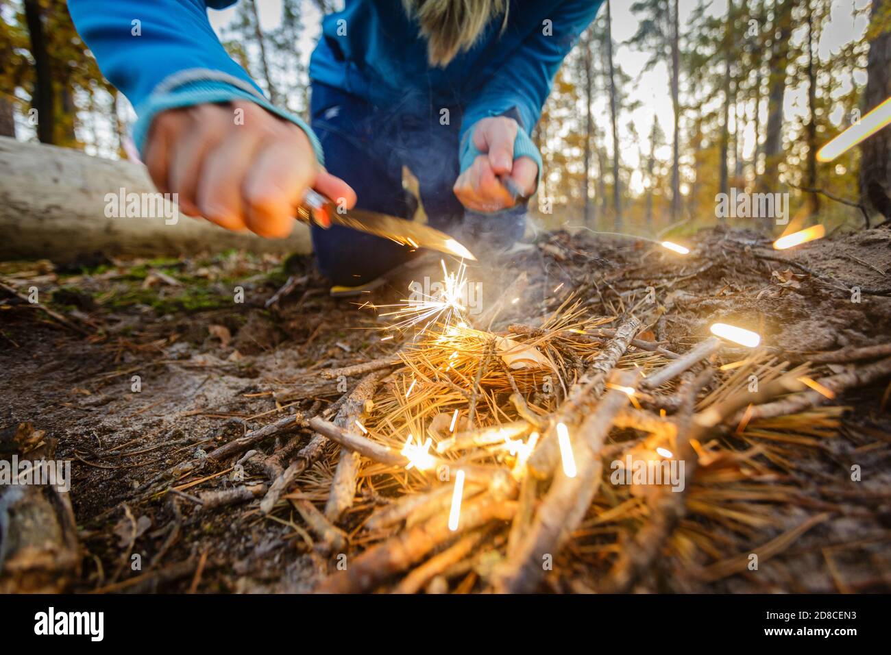 Man outdoors makeing fire by flint. Front view. Flying sparks Stock ...