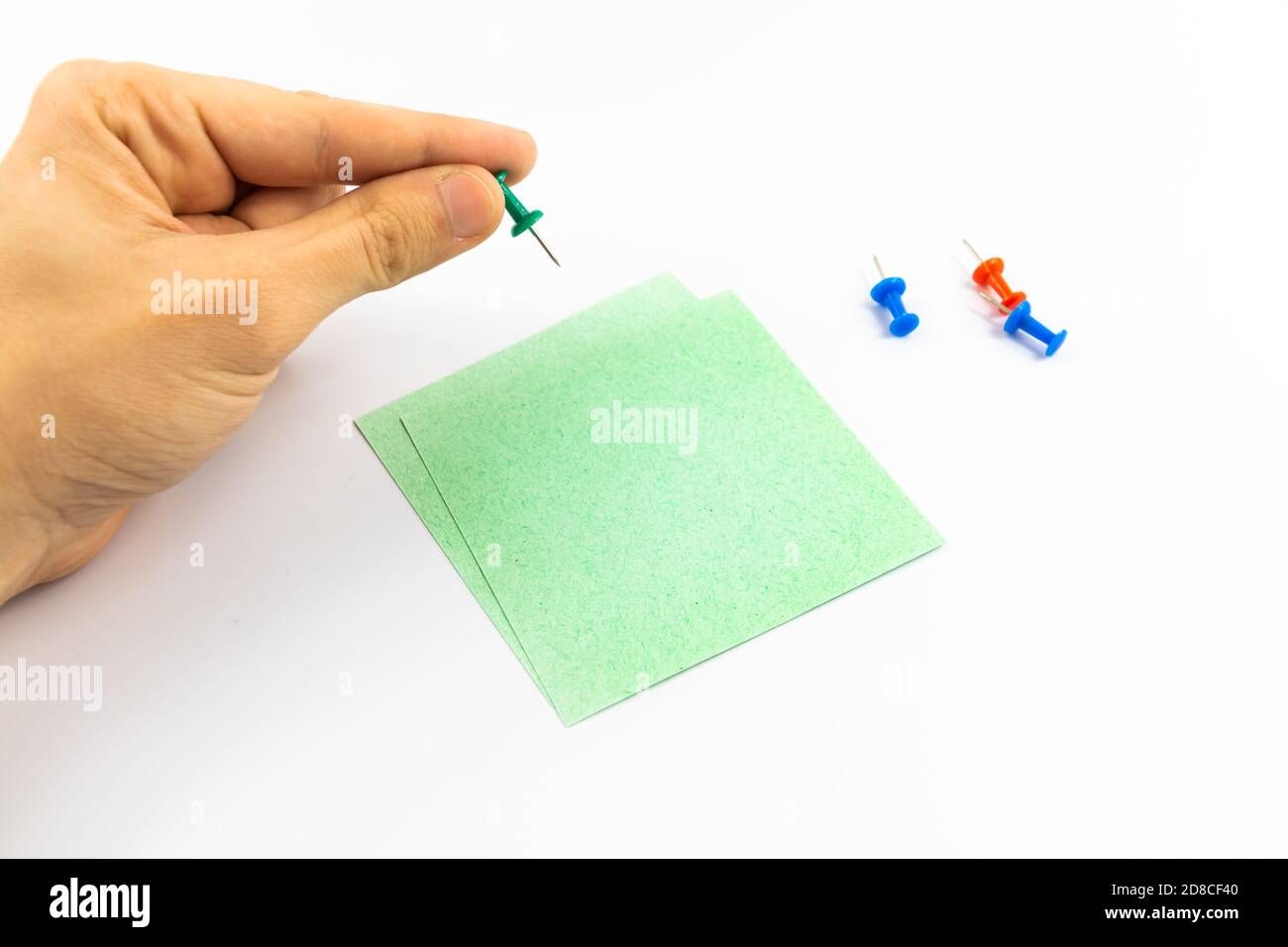 Man attaches sheet of paper with a push pin on white isolated ...