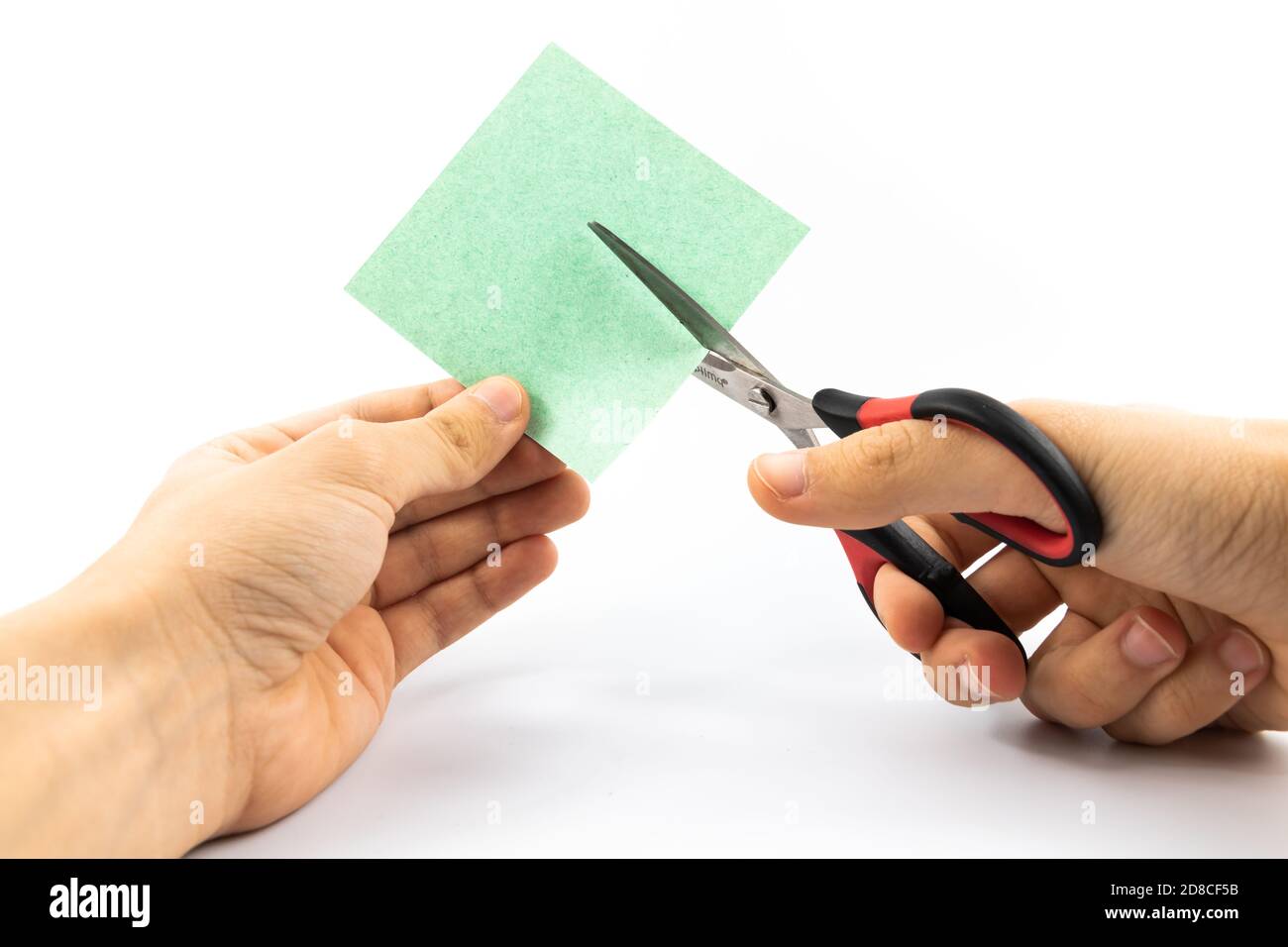 Man cuts paper with stationery scissors on white isolated background ...