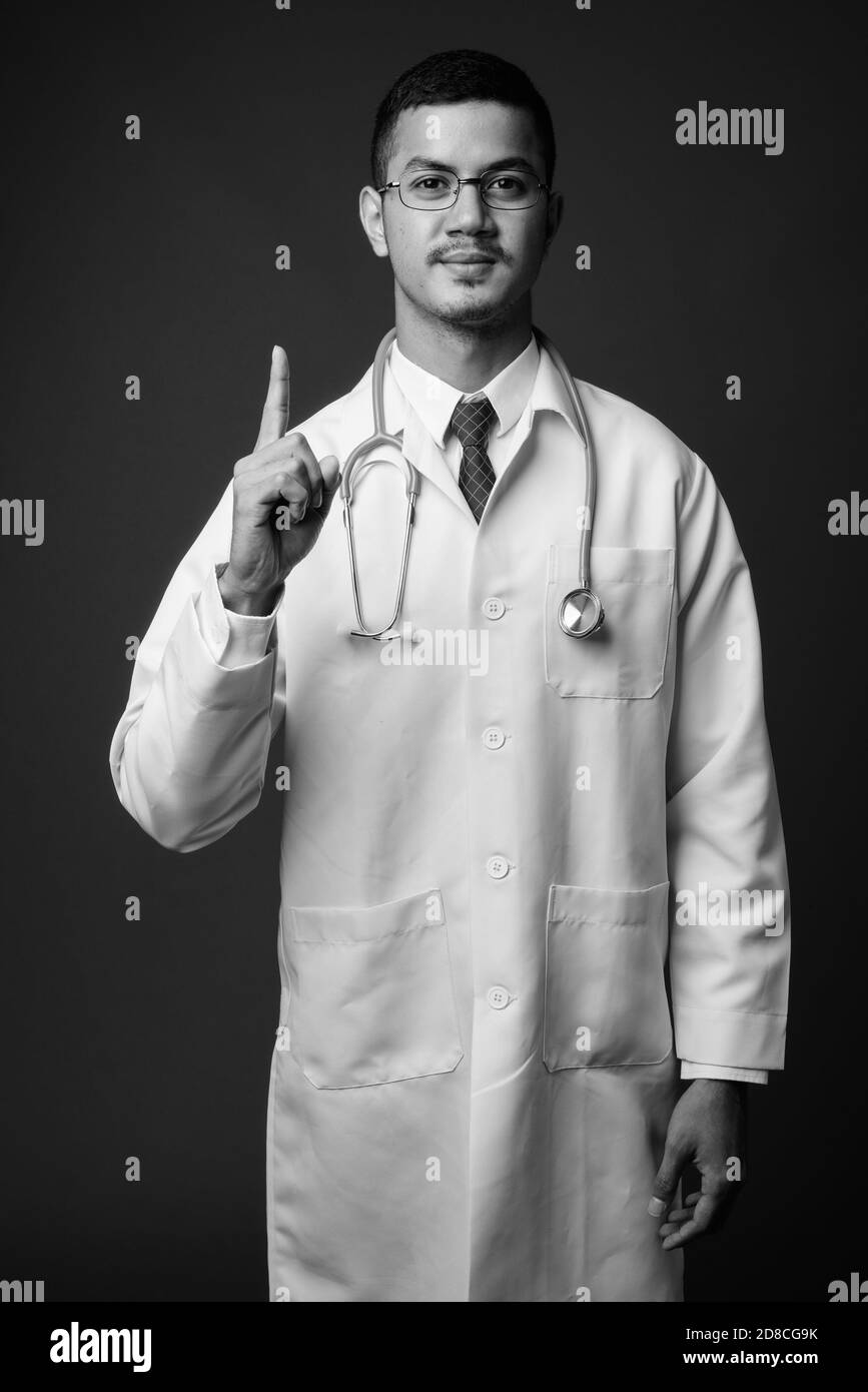 Young multi ethnic Asian man doctor against gray background Stock Photo ...