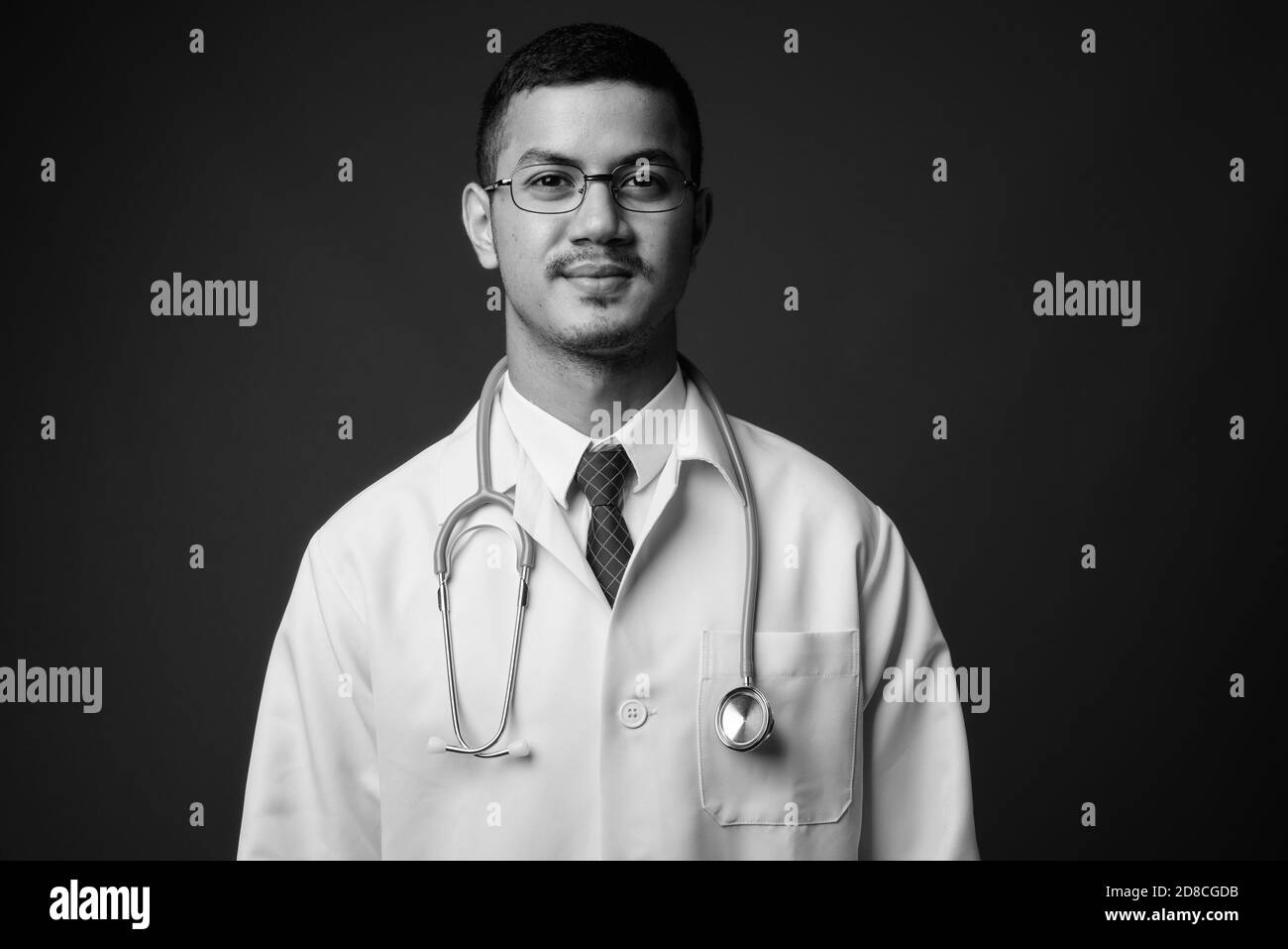 Young multi ethnic Asian man doctor against gray background Stock Photo ...