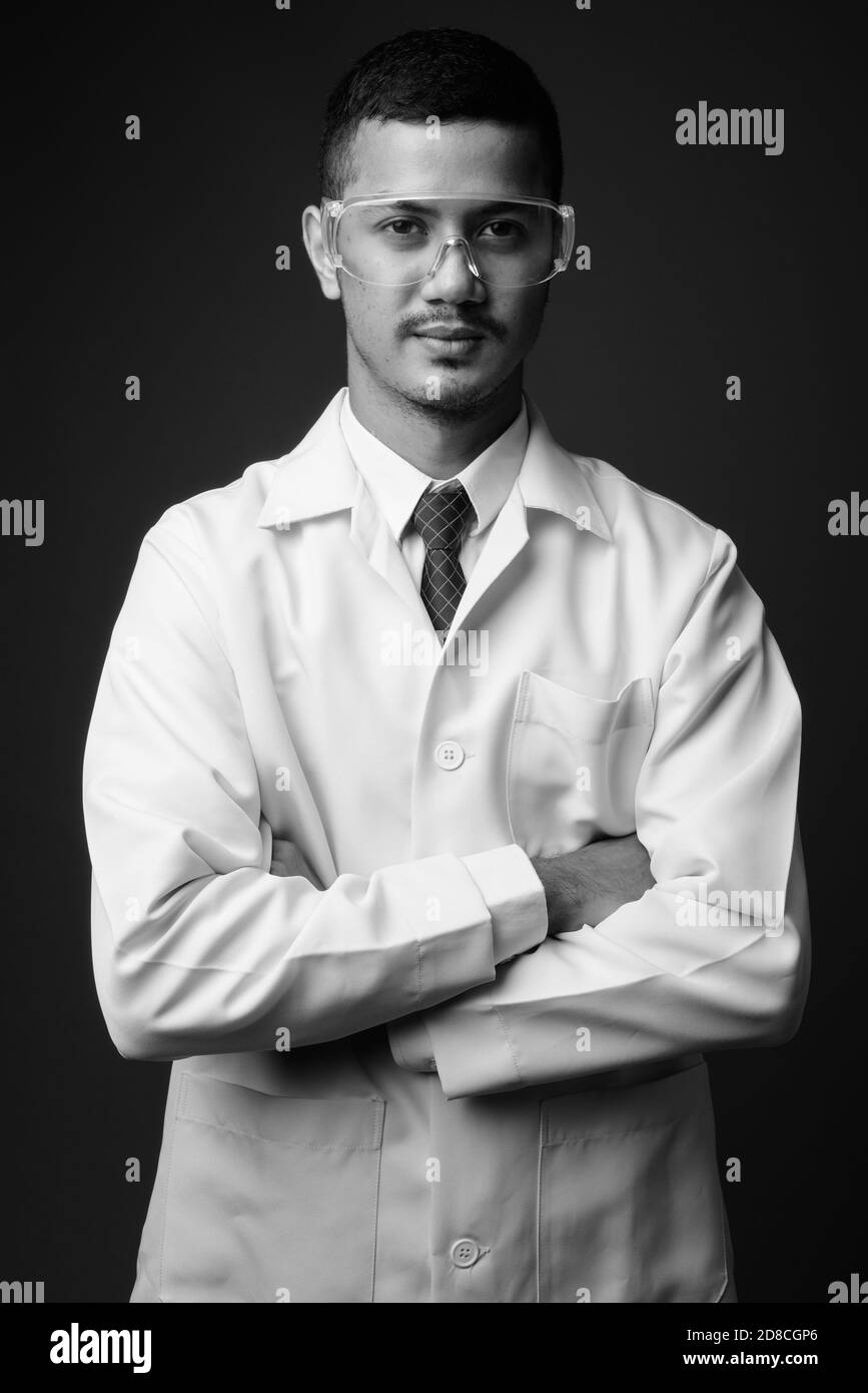 Young multi ethnic Asian man doctor against gray background Stock Photo ...