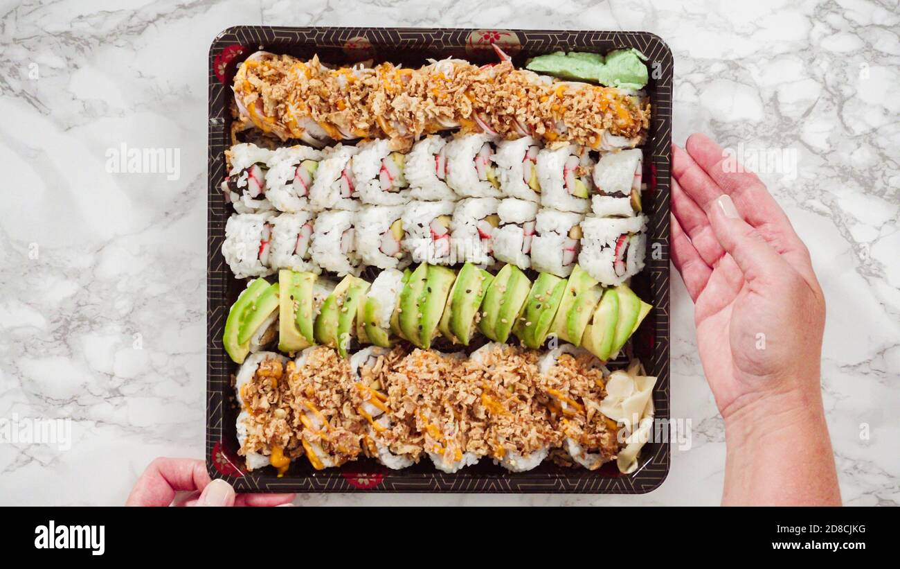 Flat lay. Pre-packaged variety of sushi and sushi rolls in a plastic ...