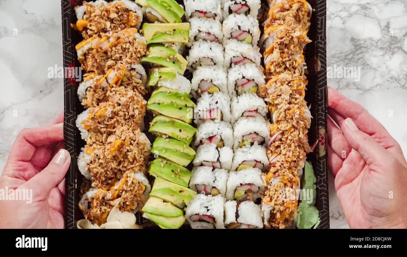 Flat lay. Pre-packaged variety of sushi and sushi rolls in a plastic ...