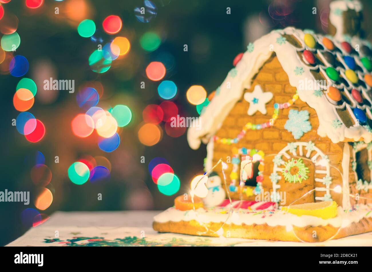 gingerbread house with blurred garland lights background Stock Photo ...